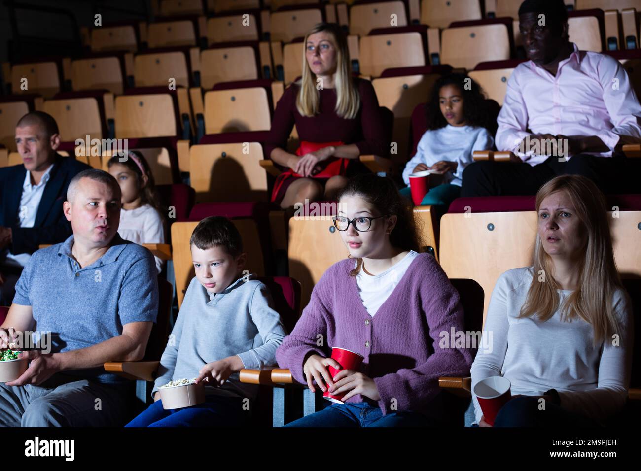 Spectators eating popcorn and watching a movie at cinema Stock Photo ...