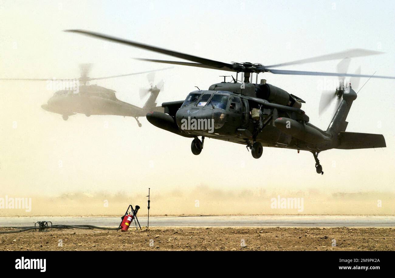Two US Army (USA) HH-60 Black Hawk helicopters land at a Forward Area ...