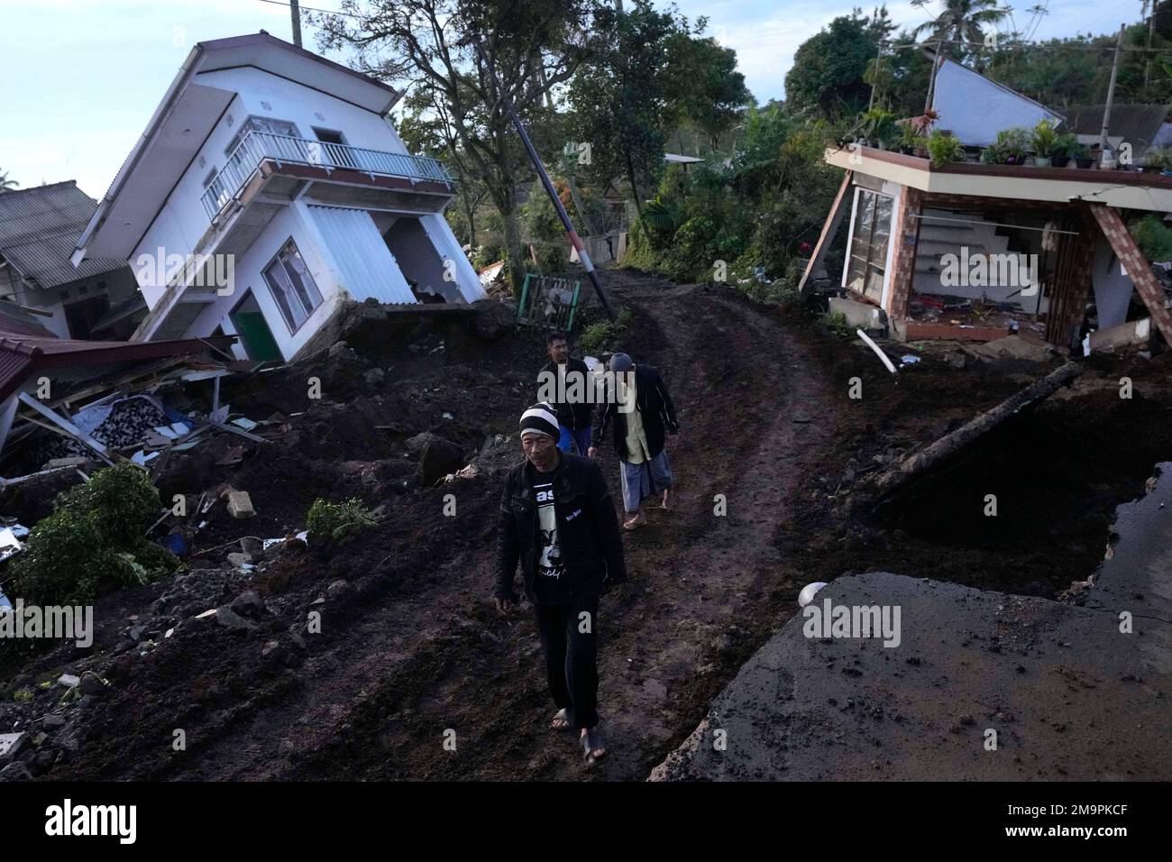 Residents walk past ruined homes damaged in Monday's earthquake in ...