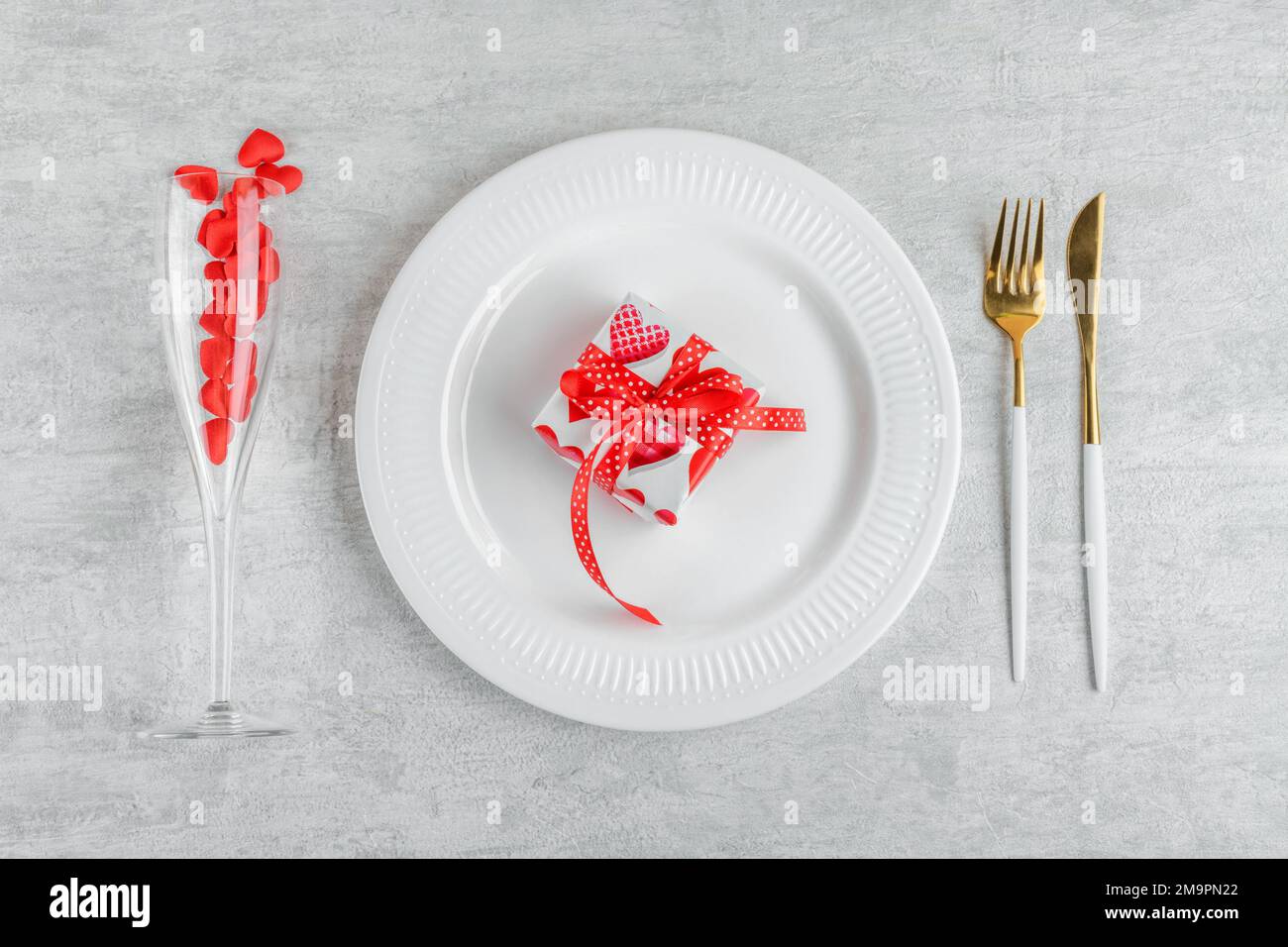 Valentines day dinner background with gift on white plate, cutlery and ...
