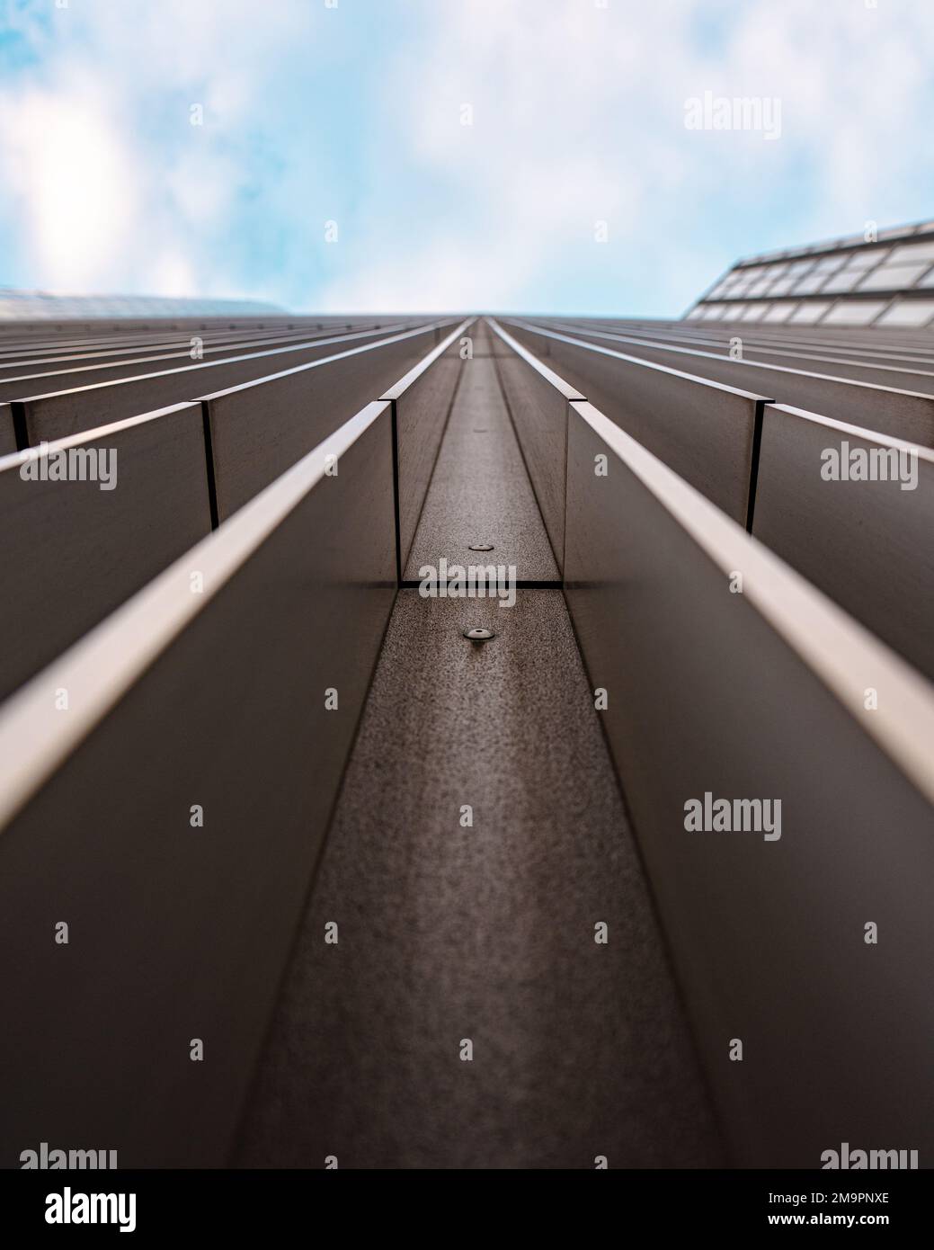 A vertical shot of a metal facade structure with parallel rising lines ...