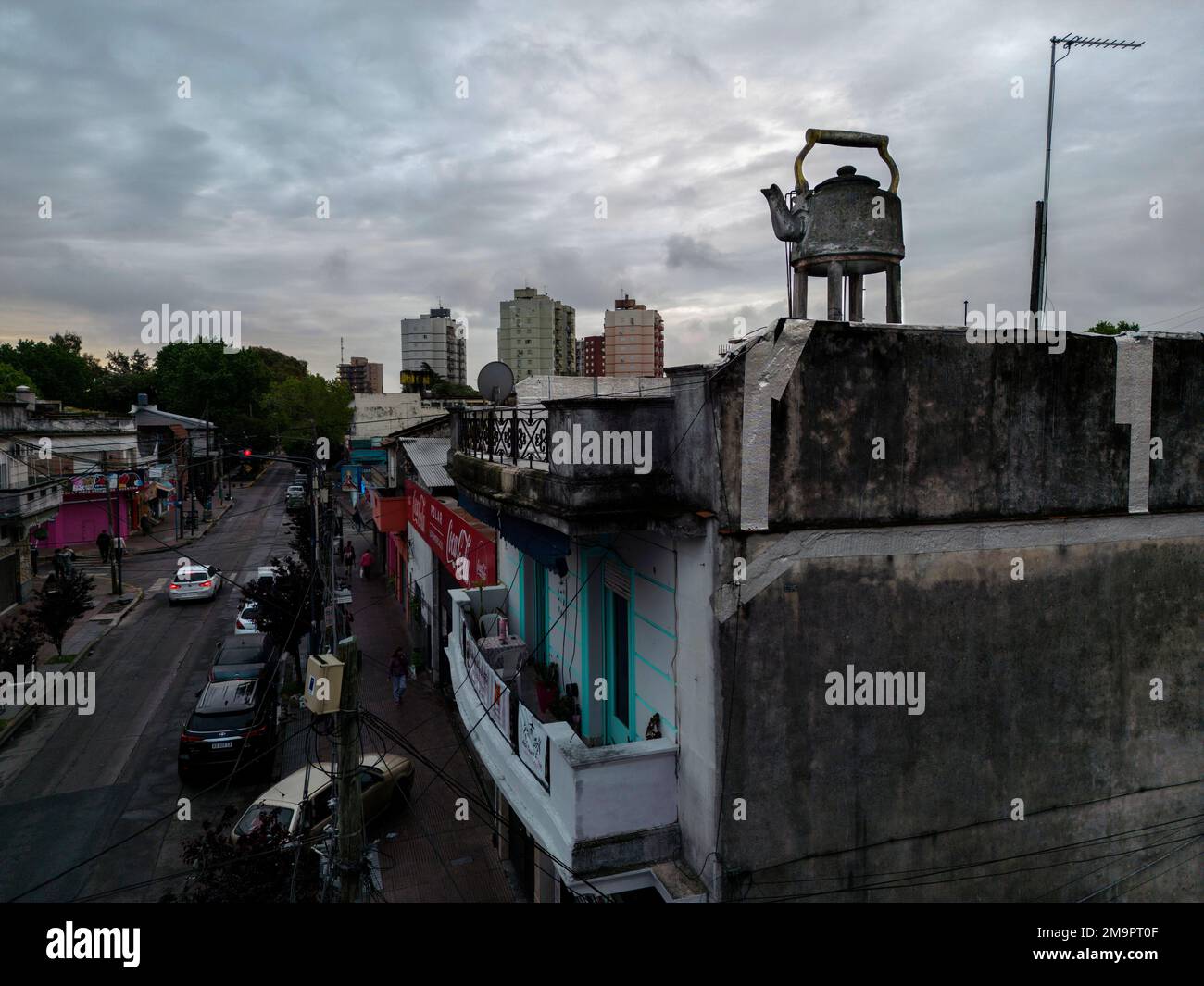 On the terrace of a two-story house stands a large water tank in the ...