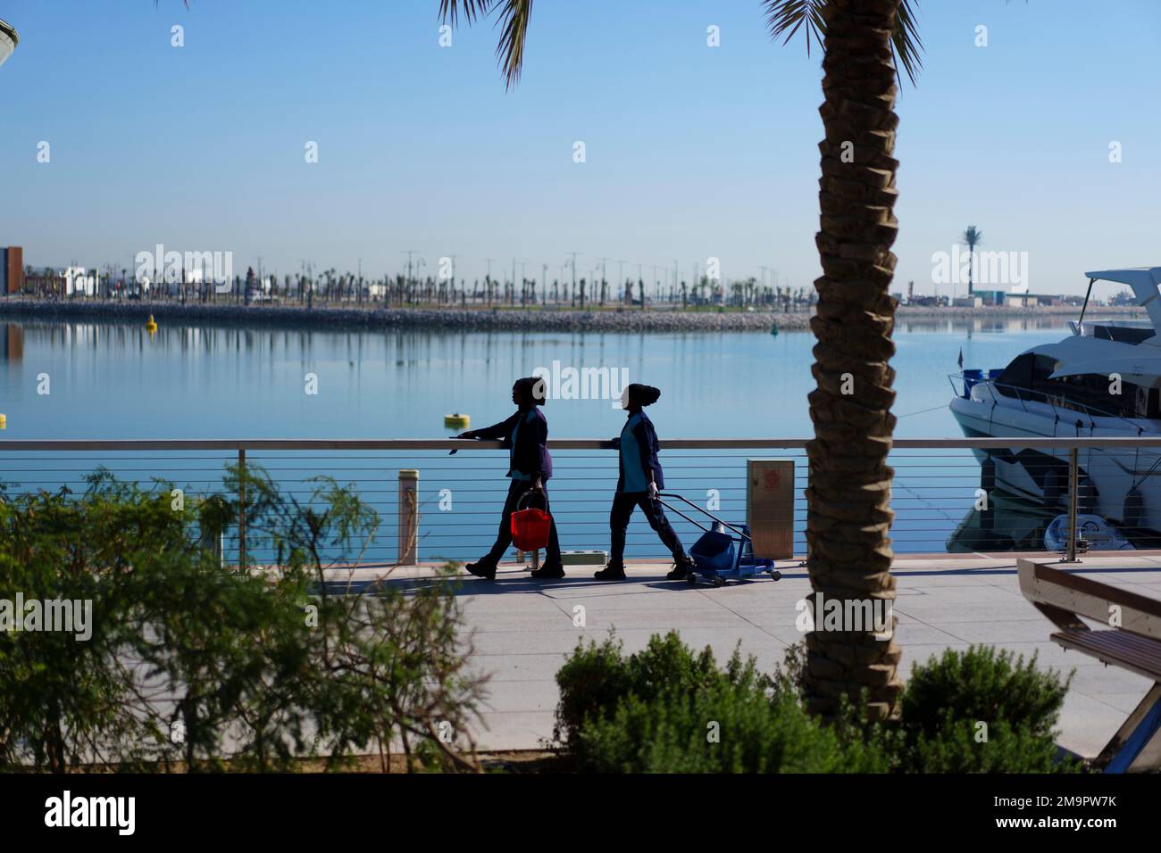 Municipal workers clean a handrail at Lusail Marina Corniche in Lusail ...