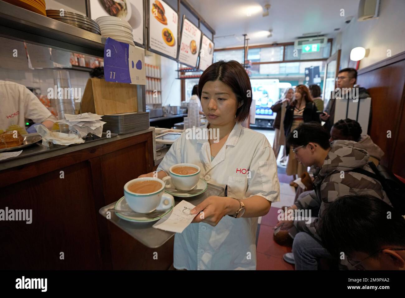 A waitress serves Hong Kong-style milk tea at the HOKO Cafe, a pop-up ...