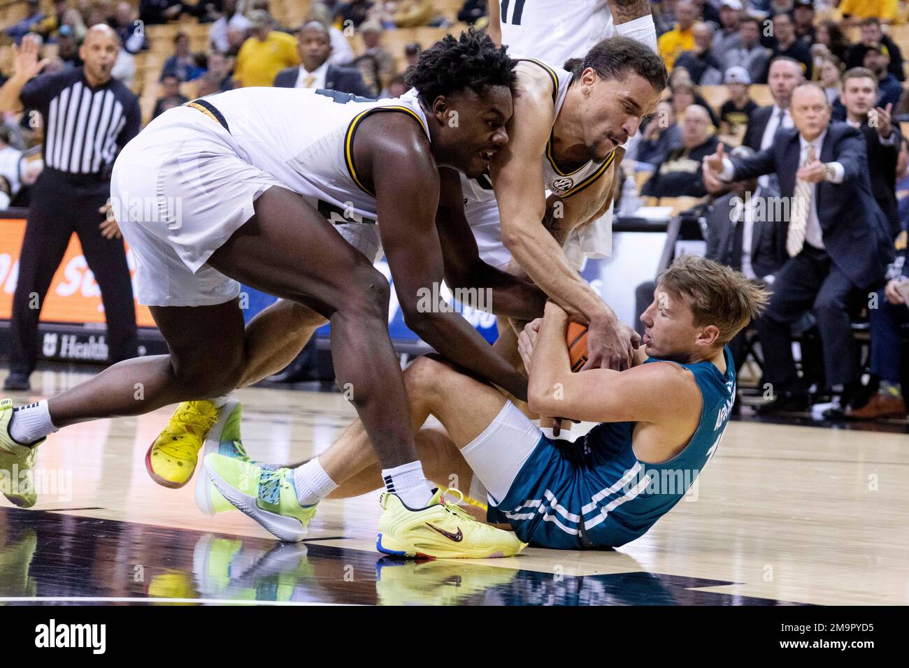 Missouri's Kobe Brown, left, and Tre Gomillion, center, grabs the ball ...