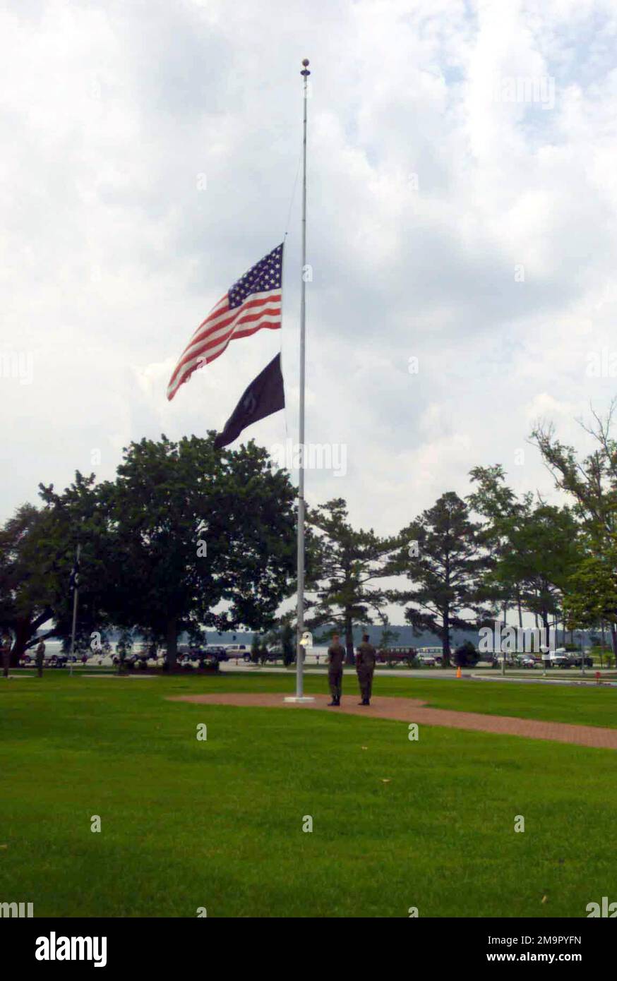 Next to the base flag pole, US Marine Corps (USMC) personnel from ...
