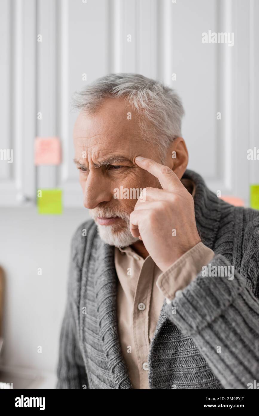 tensed man suffering from memory loss and touching head while thinking ...