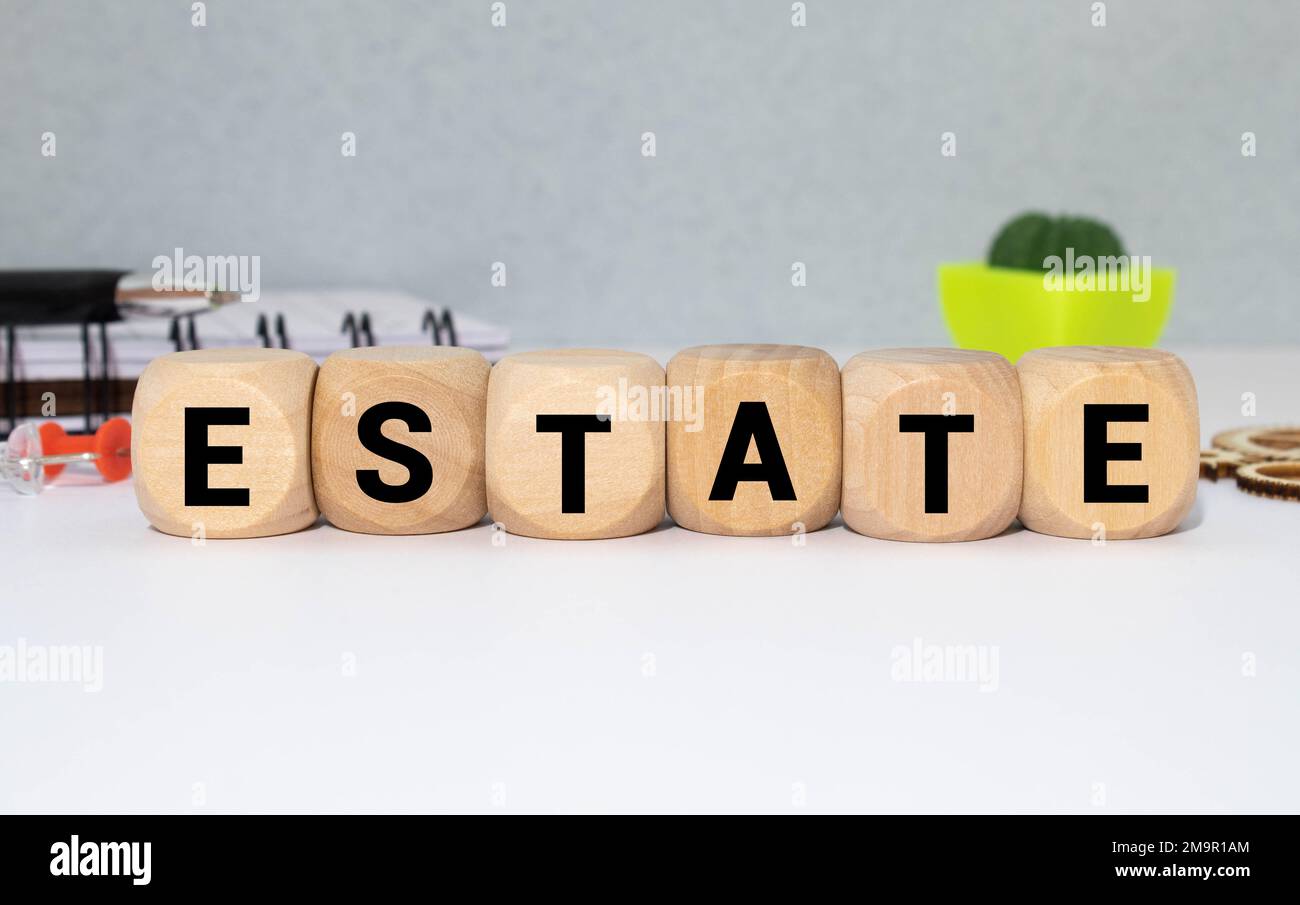 Wooden cube with word ESTATE on a wooden table background Stock Photo ...
