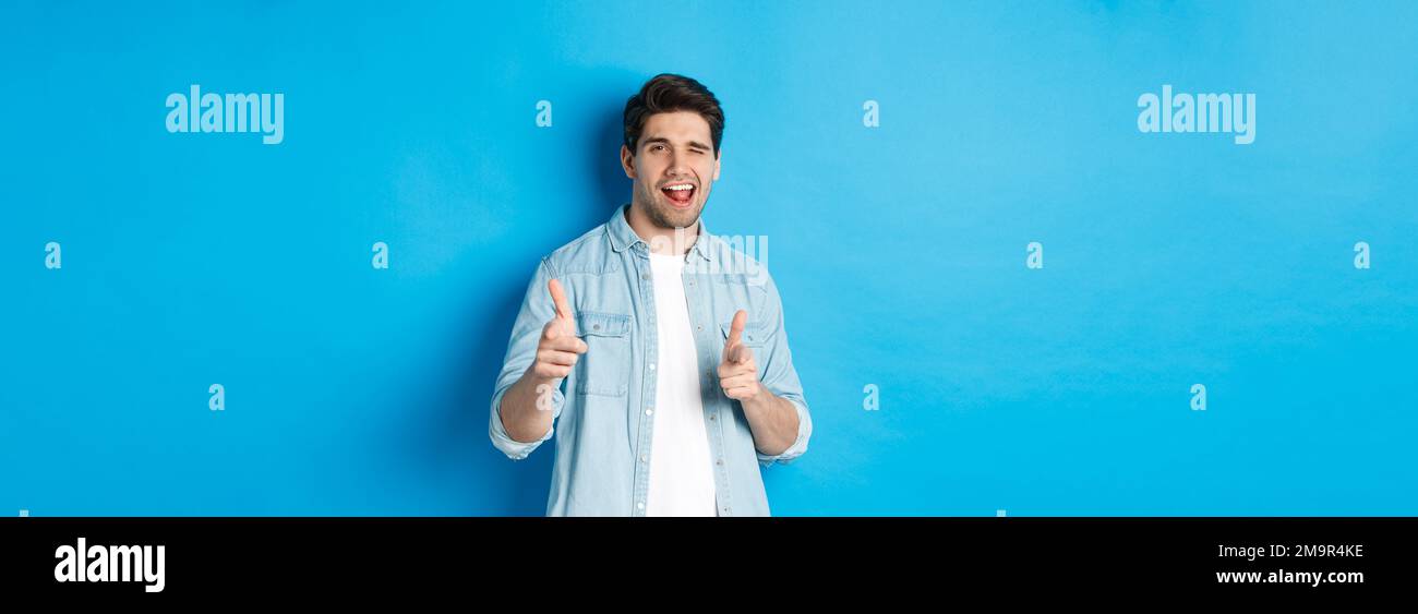 Confident adult man winking, pointing finger at you and winking ...