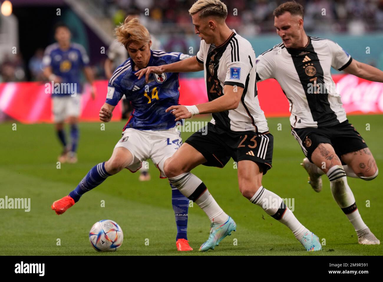 Japan's Junya Ito, left, is challenged by Germany's Nico Schlotterbeck ...