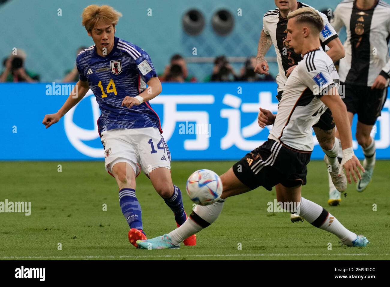 Japan's Junya Ito, left, is challenged by Germany's Nico Schlotterbeck ...