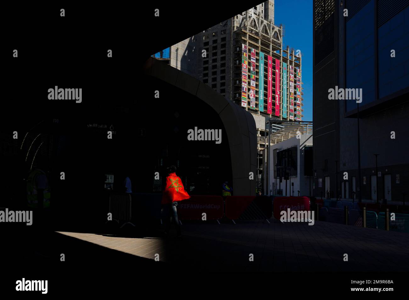 A man wearing a Moroccan flag walks toward an entrance to the metro, in ...