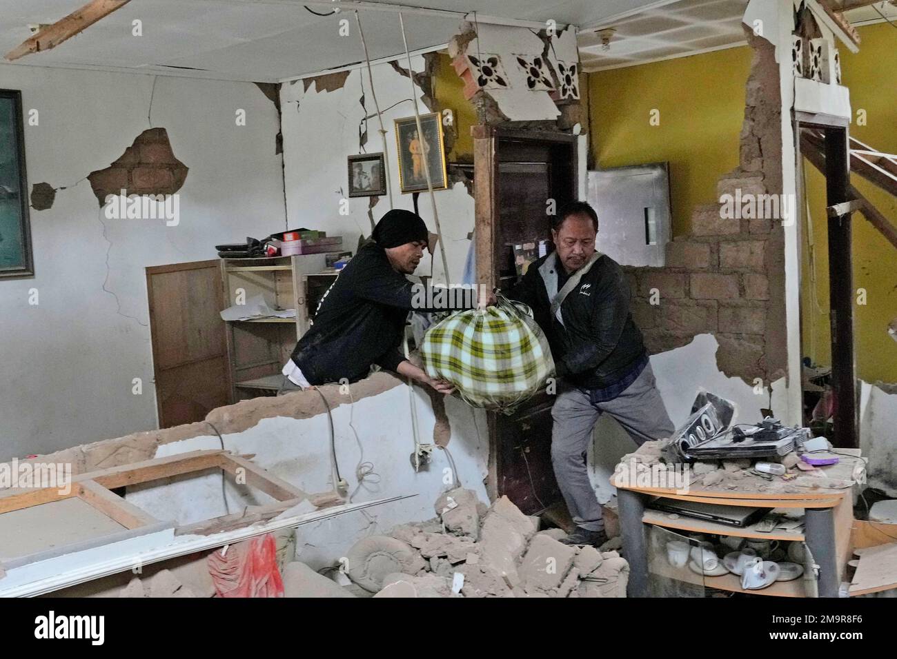 People salvage usable items from their house badly damaged during ...