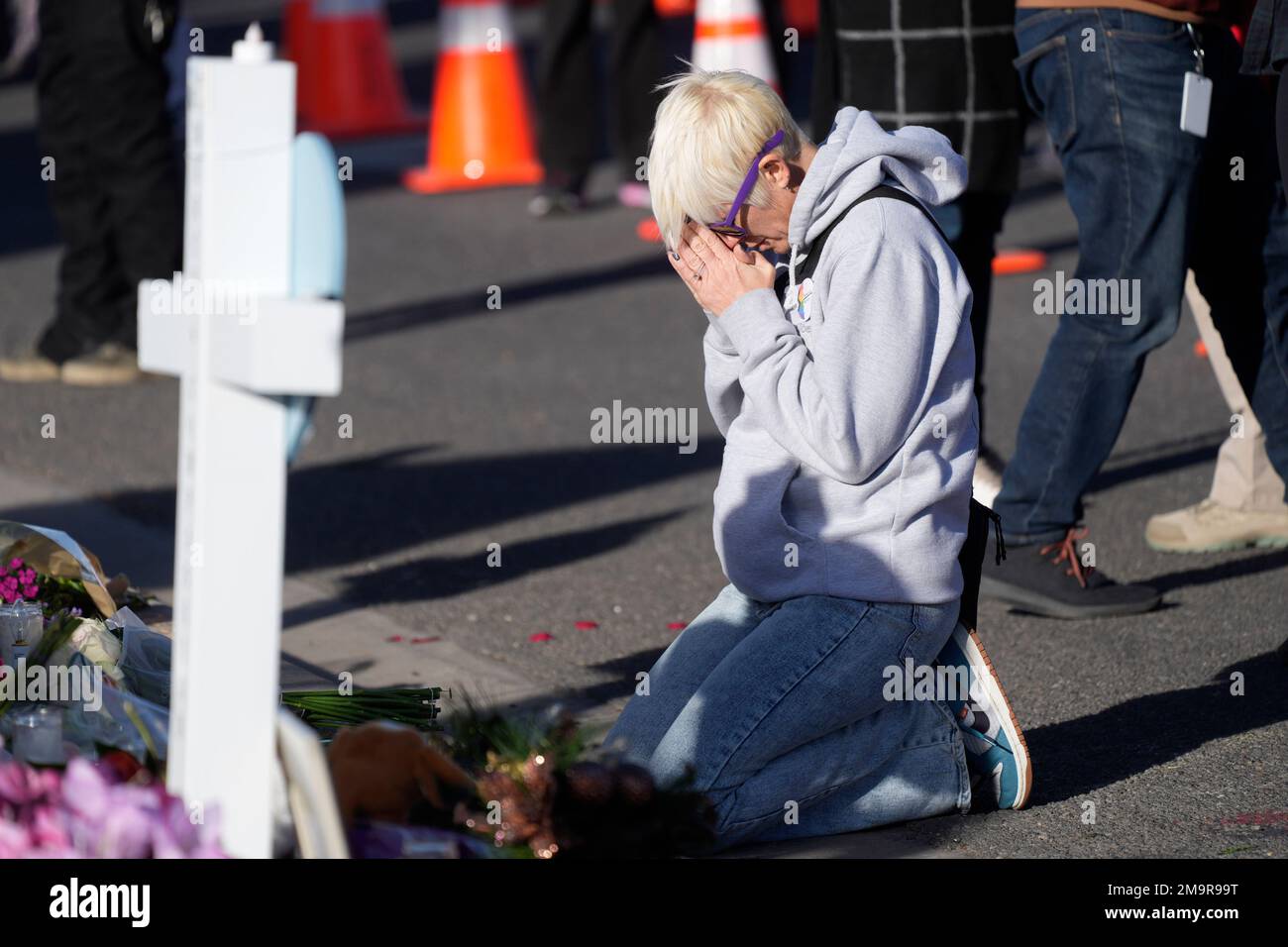 Dallas Dutka of Broomfield, Colo., prays by a makeshift memorial ...