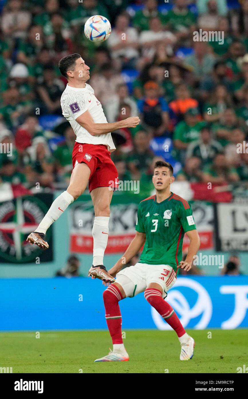 Poland's Robert Lewandowski heads the ball away from Mexico's Cesar ...