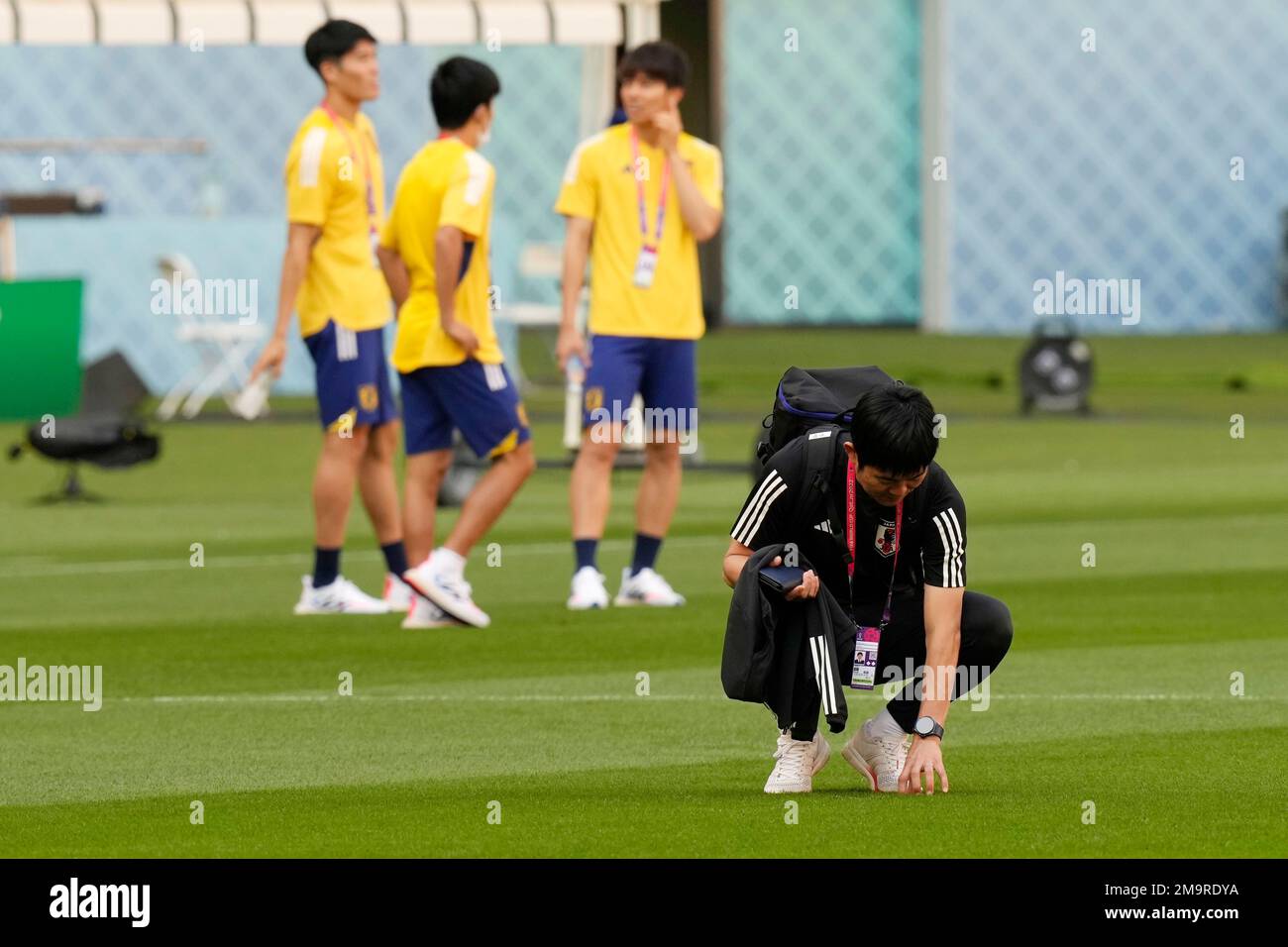 Japan's head coach Hajime Moriyasu touches the grass on the pitch at ...