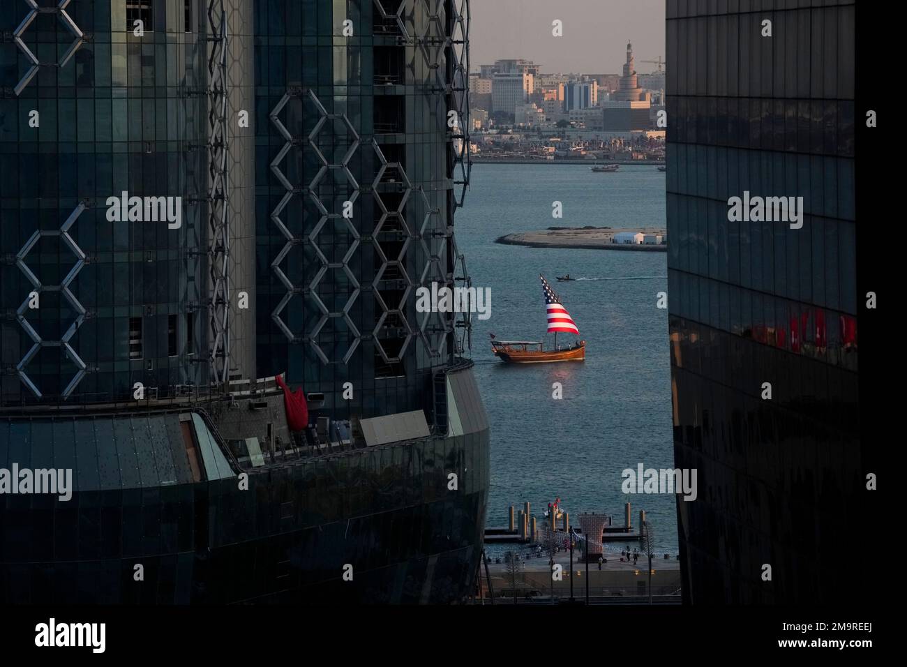 A boat with an American flag sail moves through Doha Harbor, in Doha ...