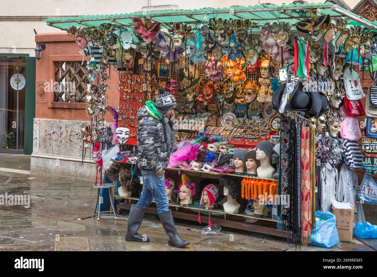 A stall keeper talks on the phone by his booth of souvenirs on a ...