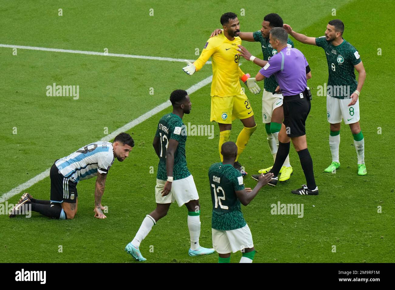 The referee interacts with Saudi Arabia's goalkeeper Mohammed Al-Owais ...