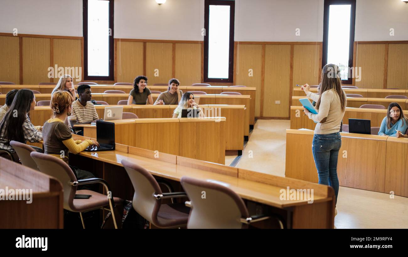 Group of university students in a circular classroom attending to the ...