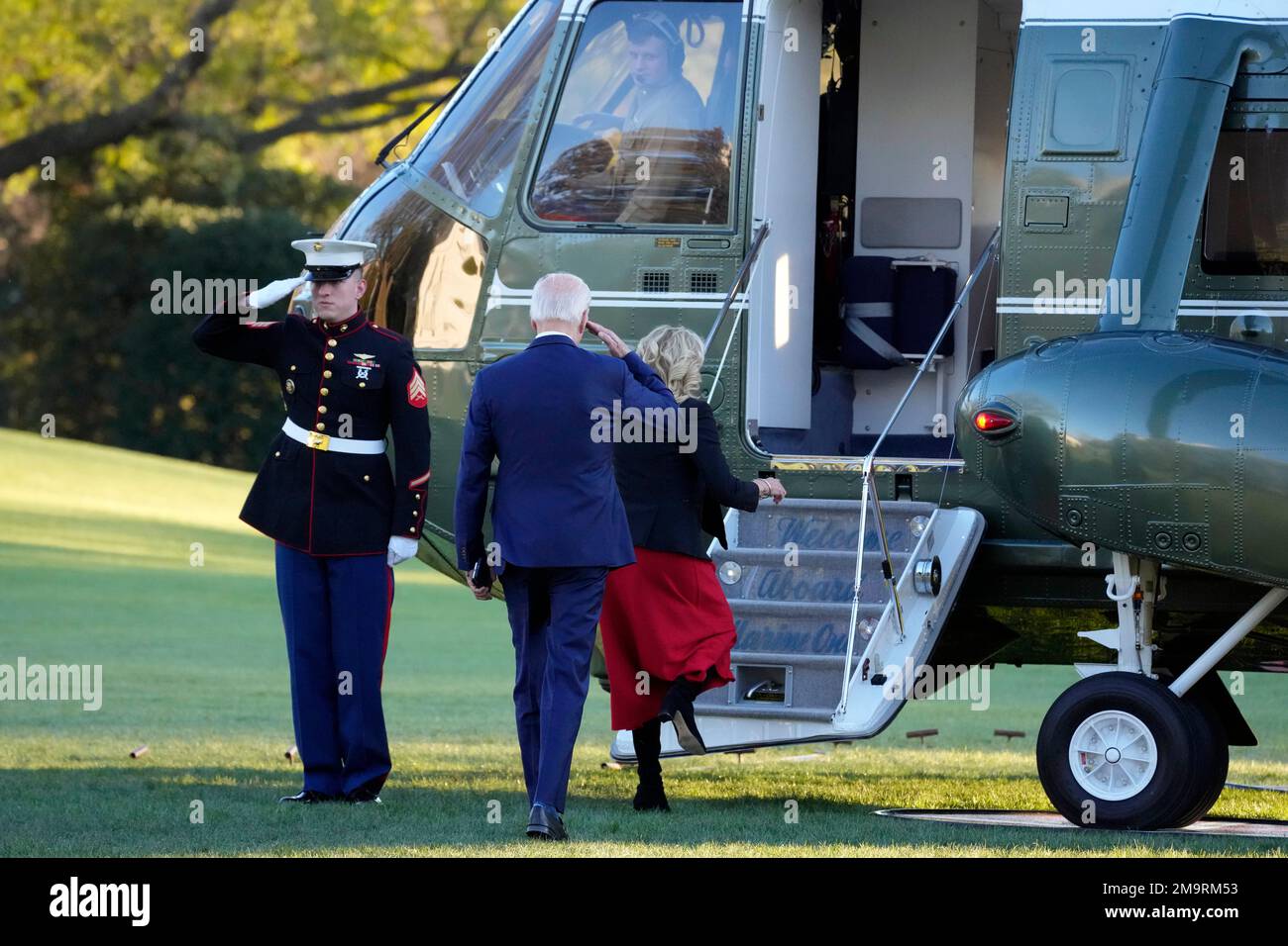 President Joe Biden returns a salute as he and first lady Jill Biden ...