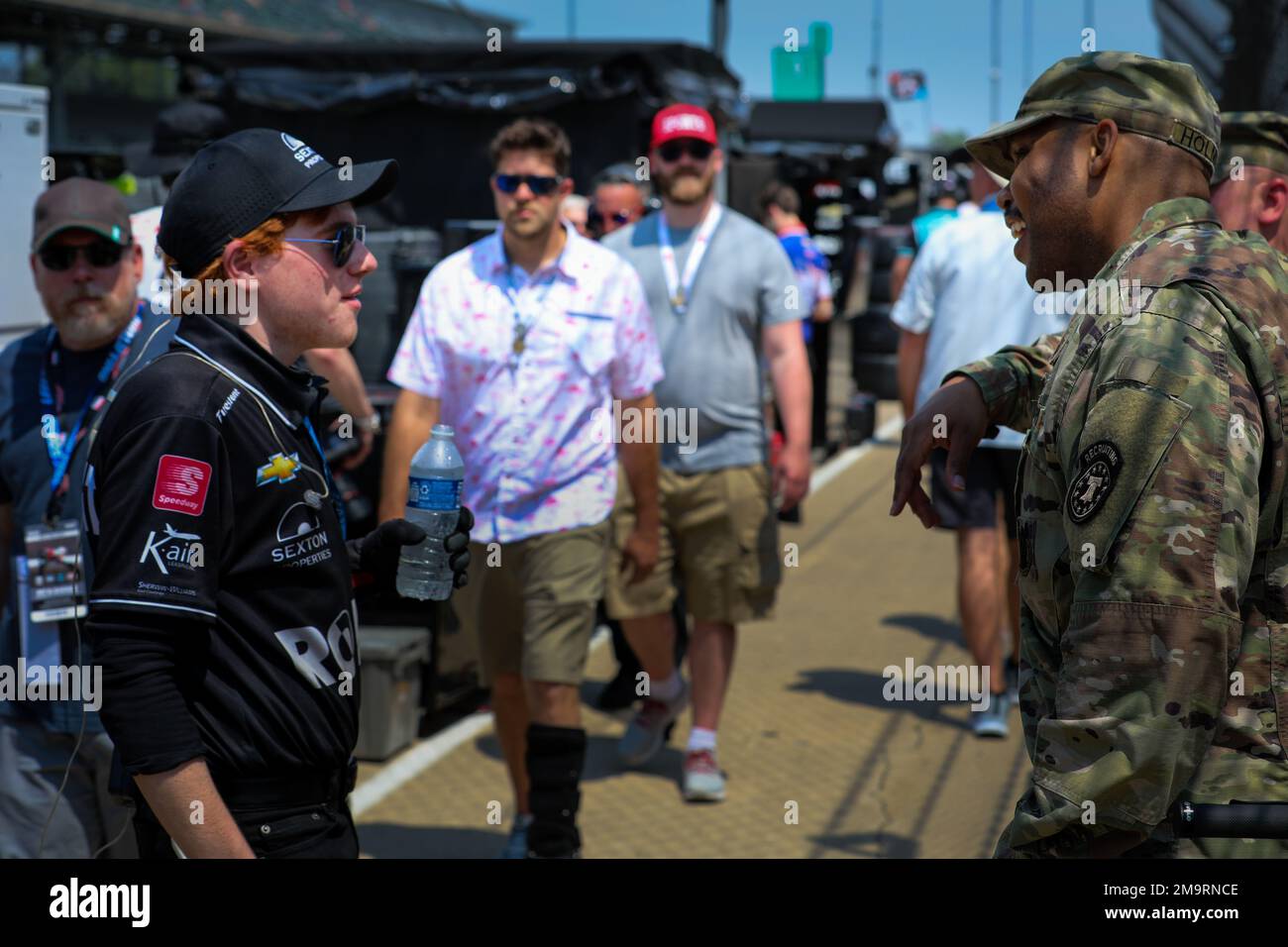 US Servicemembers speak with an A.J. Foyt Pit crewmember during the ...