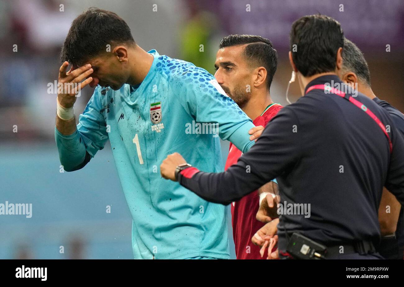 Iran's goalkeeper Alireza Beiranvand is attended by team support staff ...