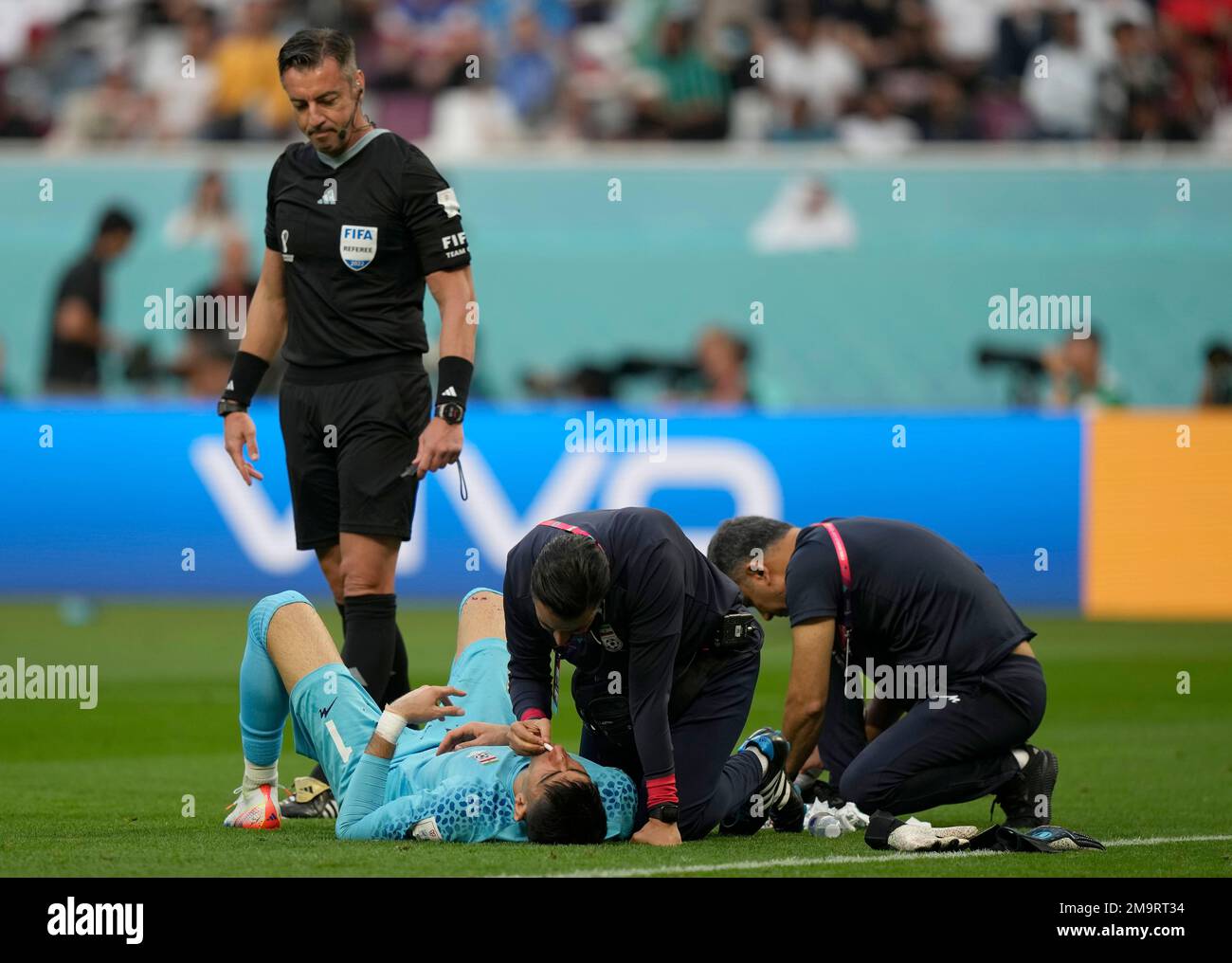 Iran's goalkeeper Alireza Beiranvand receives medical treatment during ...