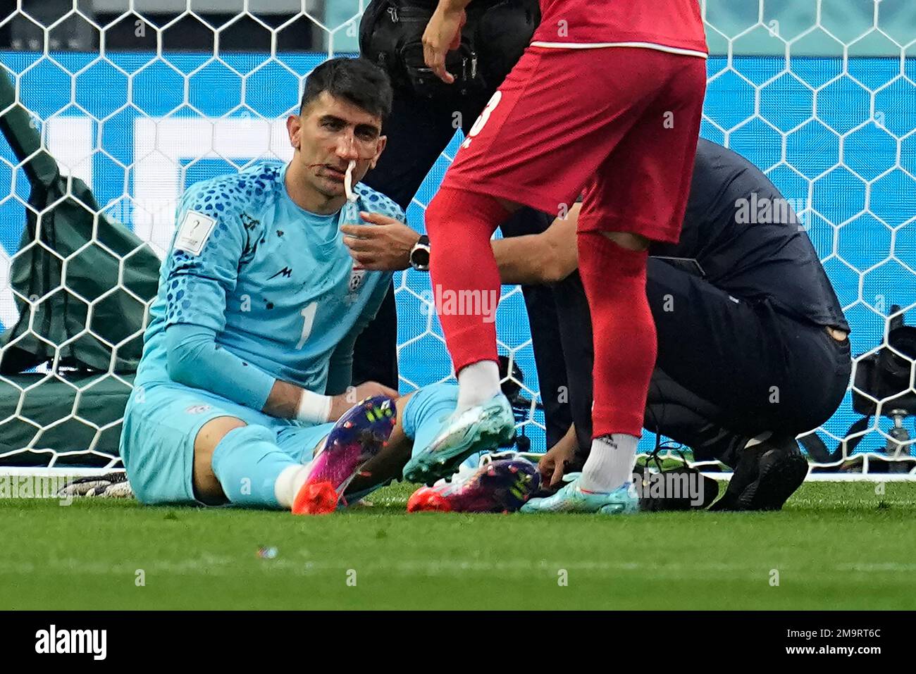 Iran's goalkeeper Alireza Beiranvand is attended by team support staff ...