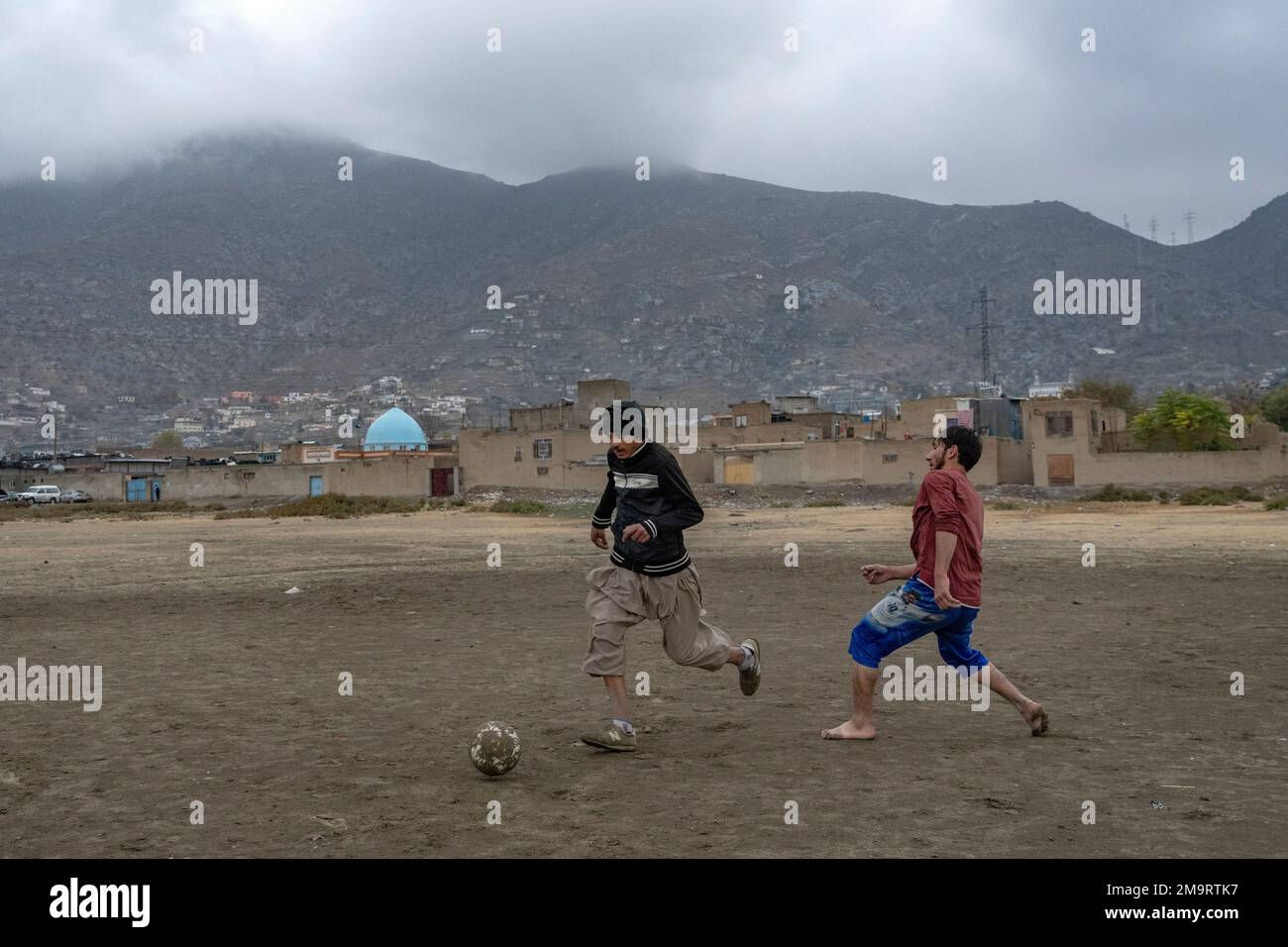 Afghan boys play football on a makeshift pitch in an open field, on the ...