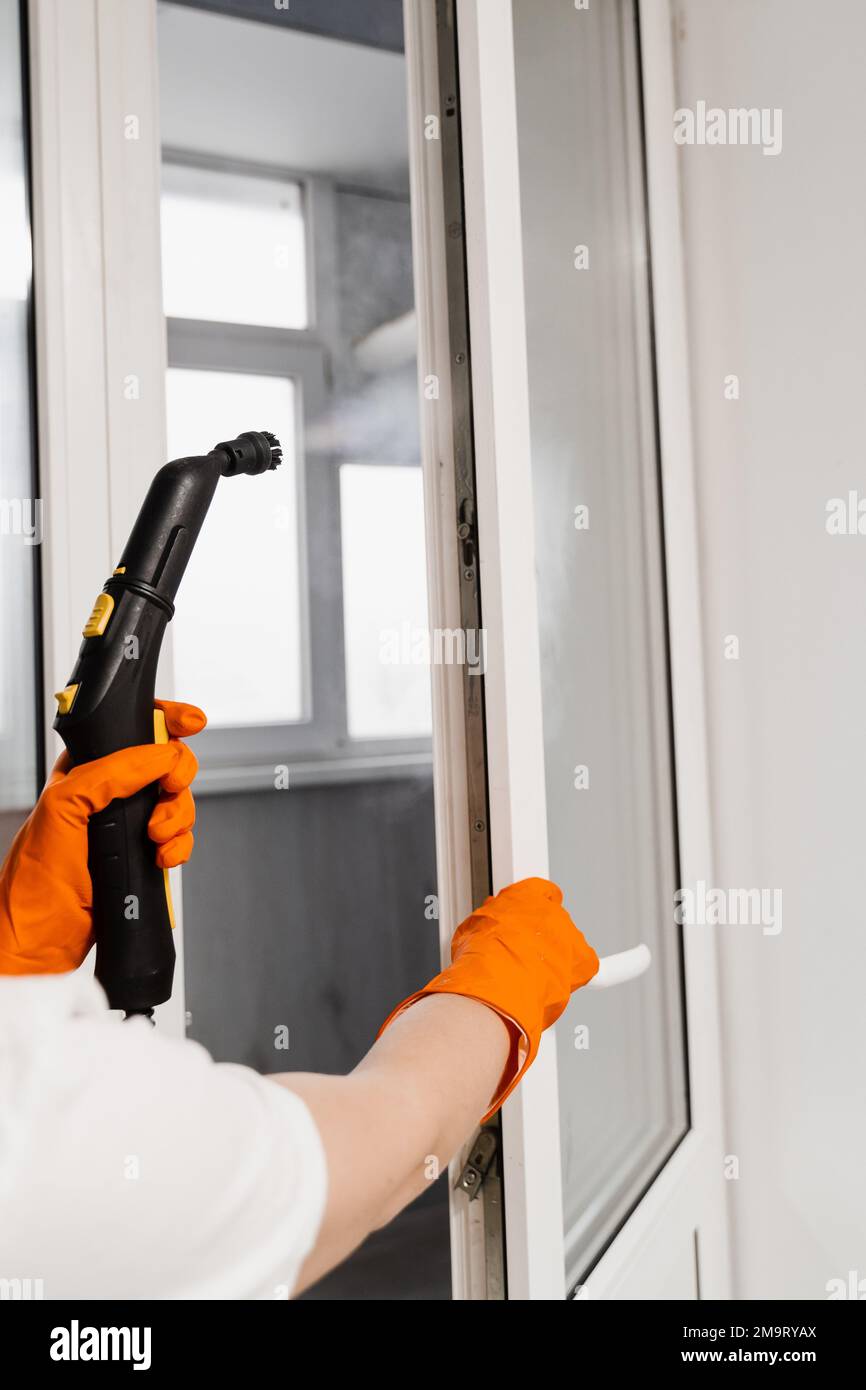 Steam cleaning of window frame at home. Professional cleaner is ...