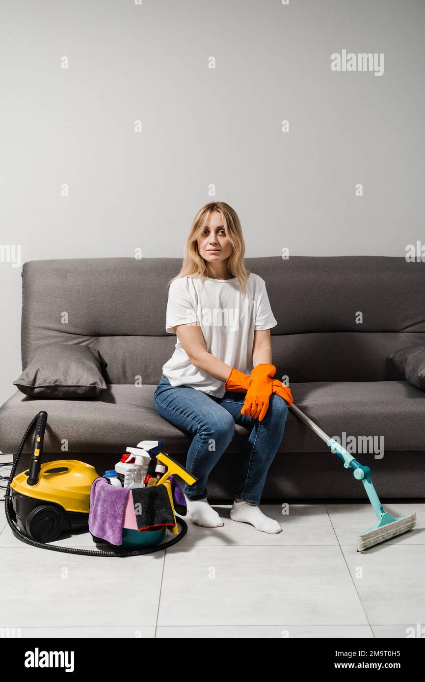 Girl cleaner with mop, bucket with detergent and rags, steam machine ...