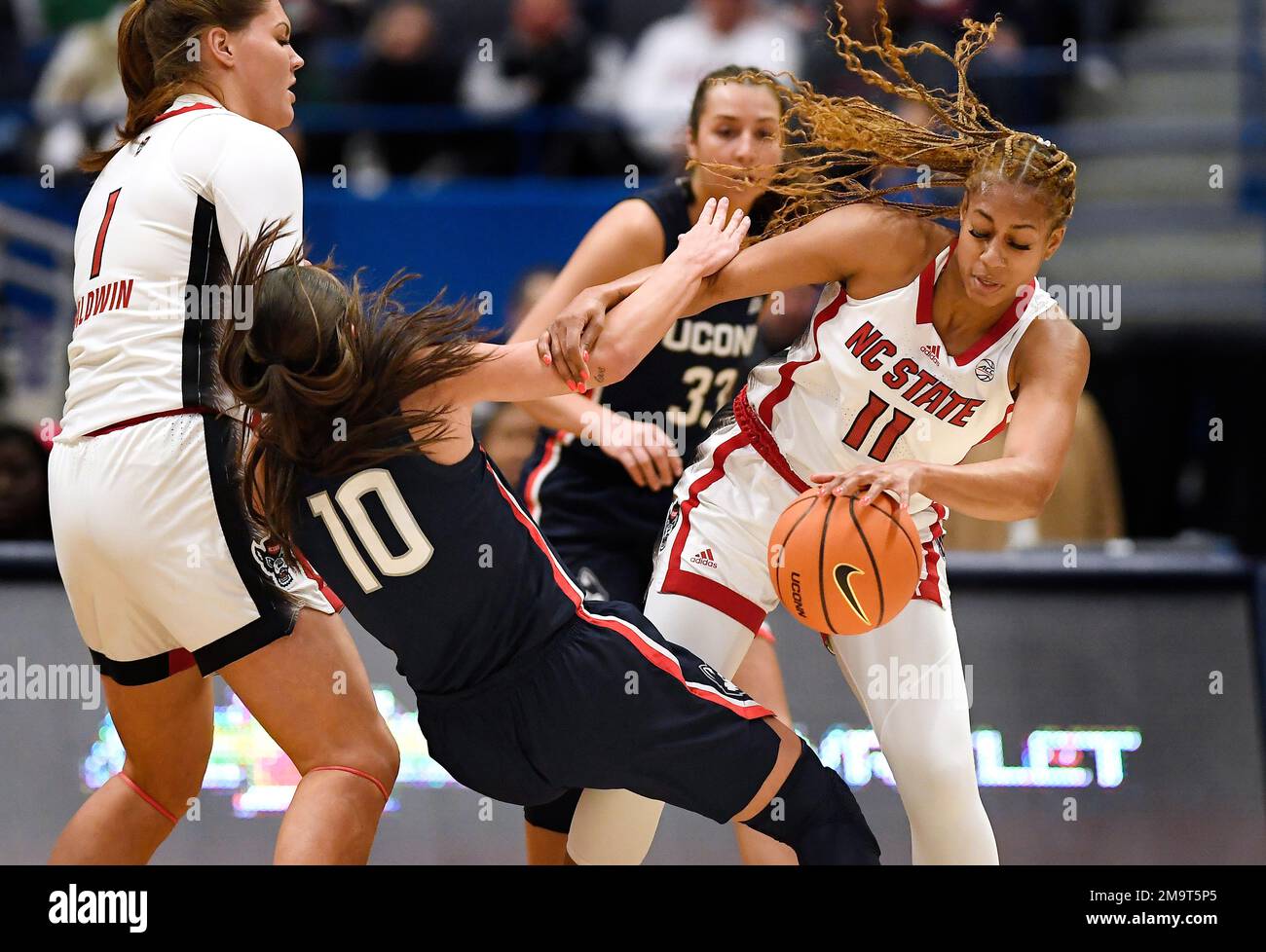 NC State's Jakia Brown-Turner (11) fouls Connecticut's Nika Muhl (10 ...