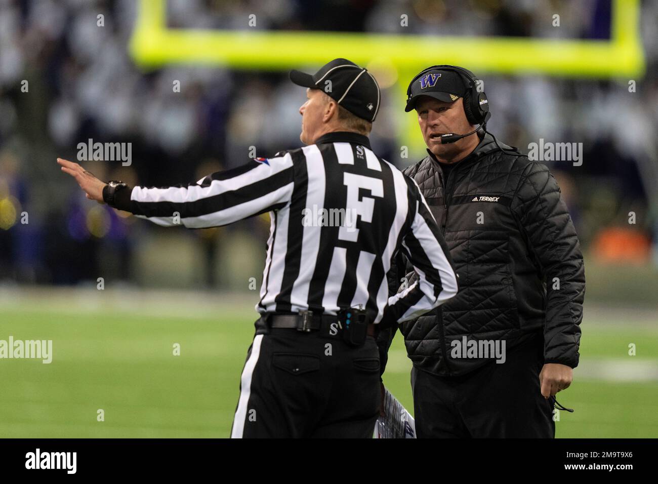 Washington coach Kalen DeBoer talks with field judge Kevin Kieser ...