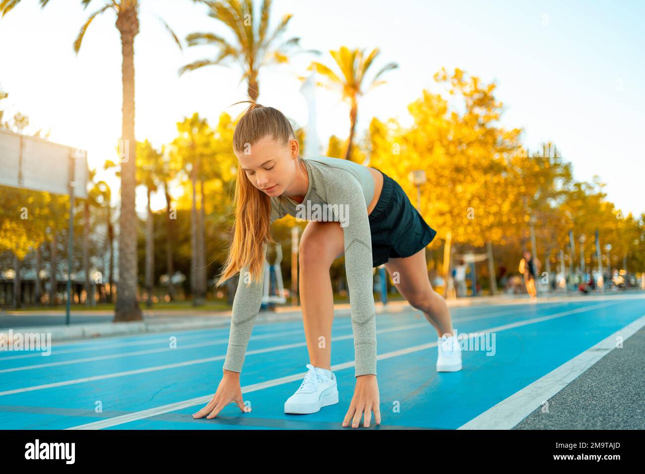 Female athlete ready to run. Fit confident woman starting position ready for running. Female ...