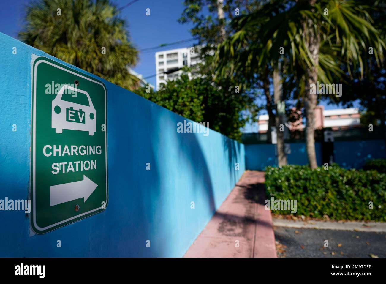 A sign pointing to an electrical vehicle charging station is displayed ...
