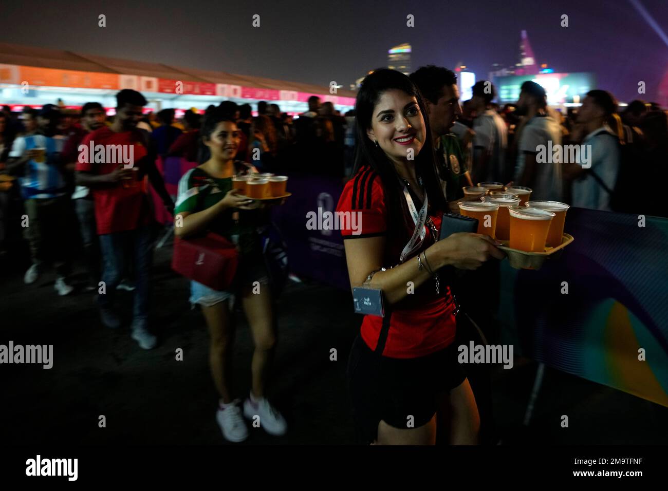 Fans carry their beers at a fan zone ahead of the FIFA World Cup, in ...