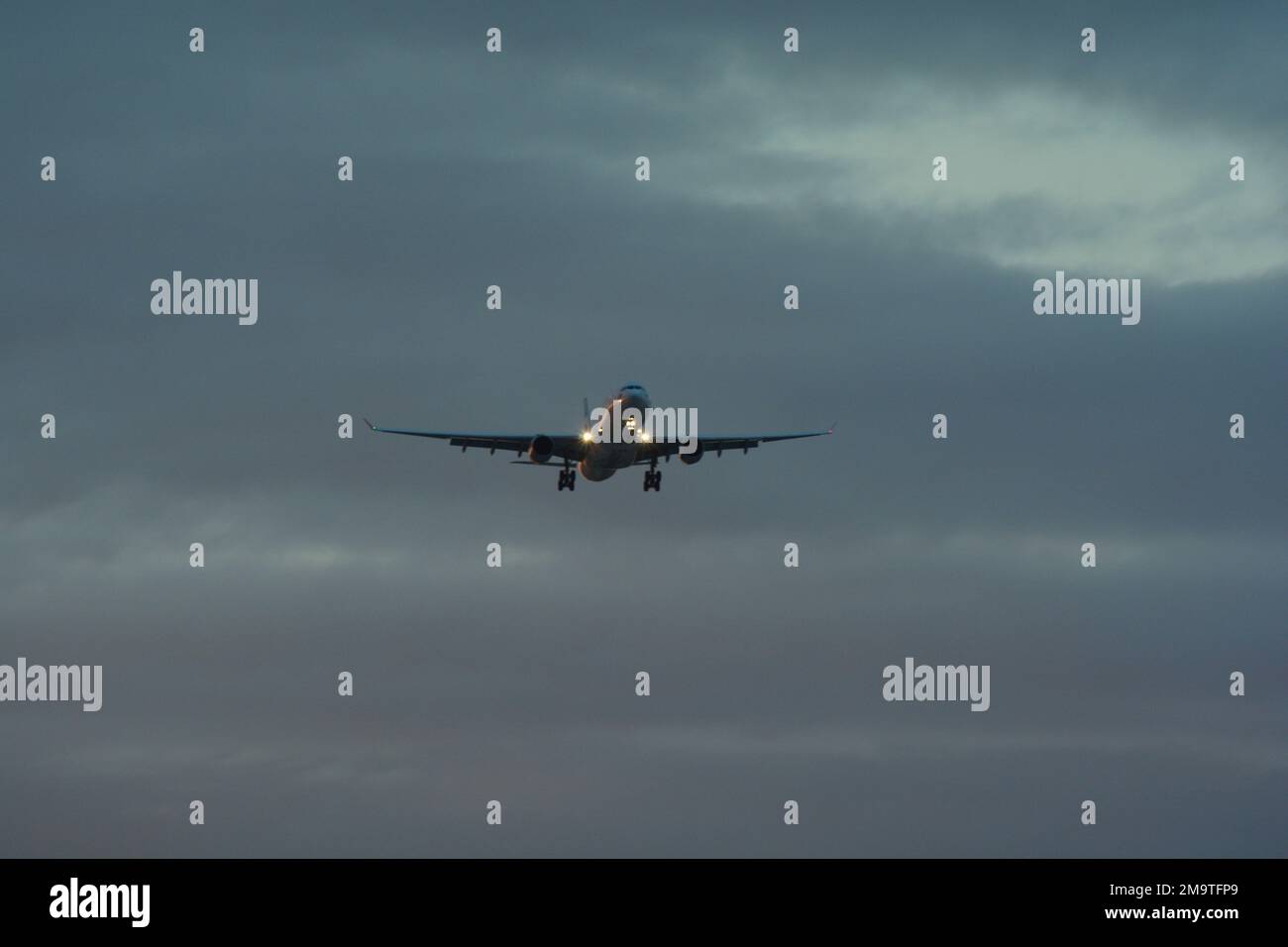 A commercial passenger jet aircraft approaching the runway for landing ...