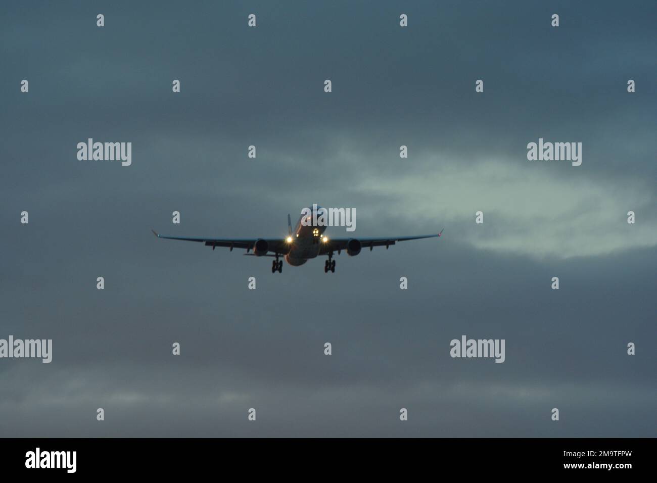 A commercial passenger jet aircraft approaching the runway for landing ...