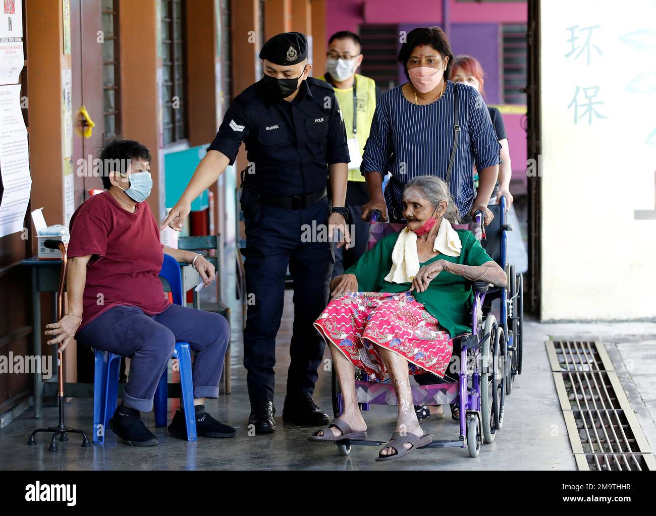 An elderly Malaysian voter on wheel chair waits in a line to cast her ...