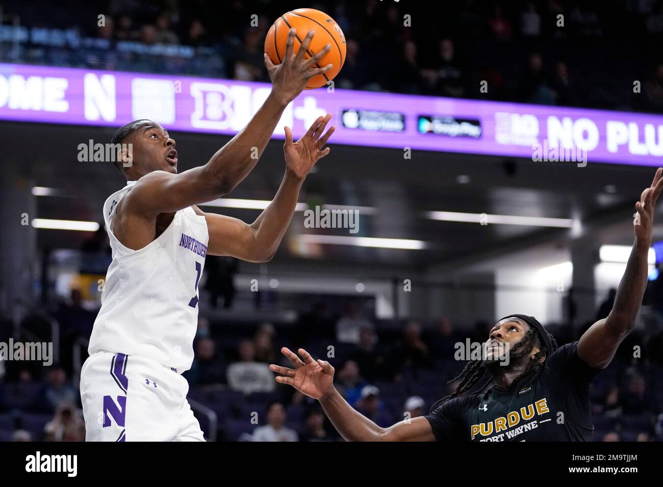 Northwestern guard Chase Audige, left, drives to the basket against ...