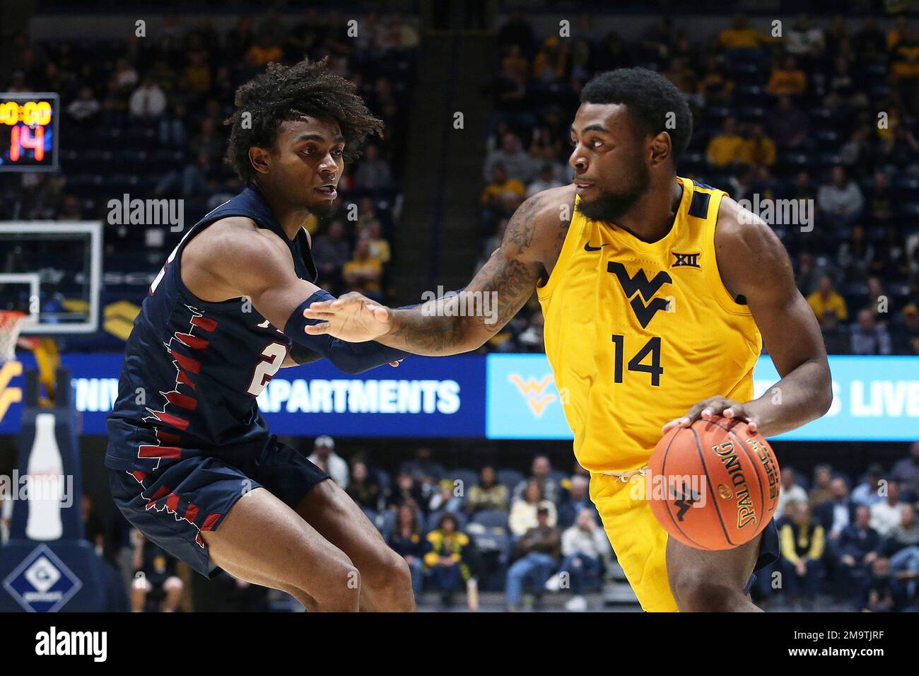 West Virginia guard Seth Wilson (14) is defended by Penn guard Lucas ...