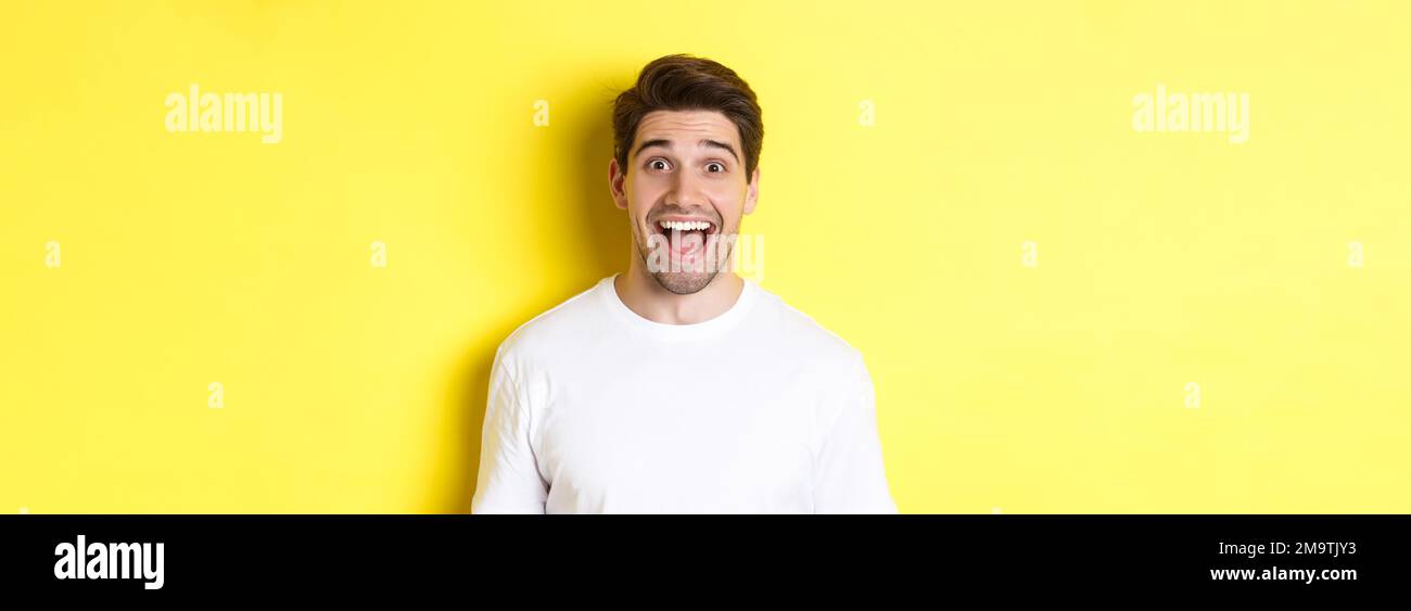Close-up of surprised handsome guy reacting to great news, standing ...