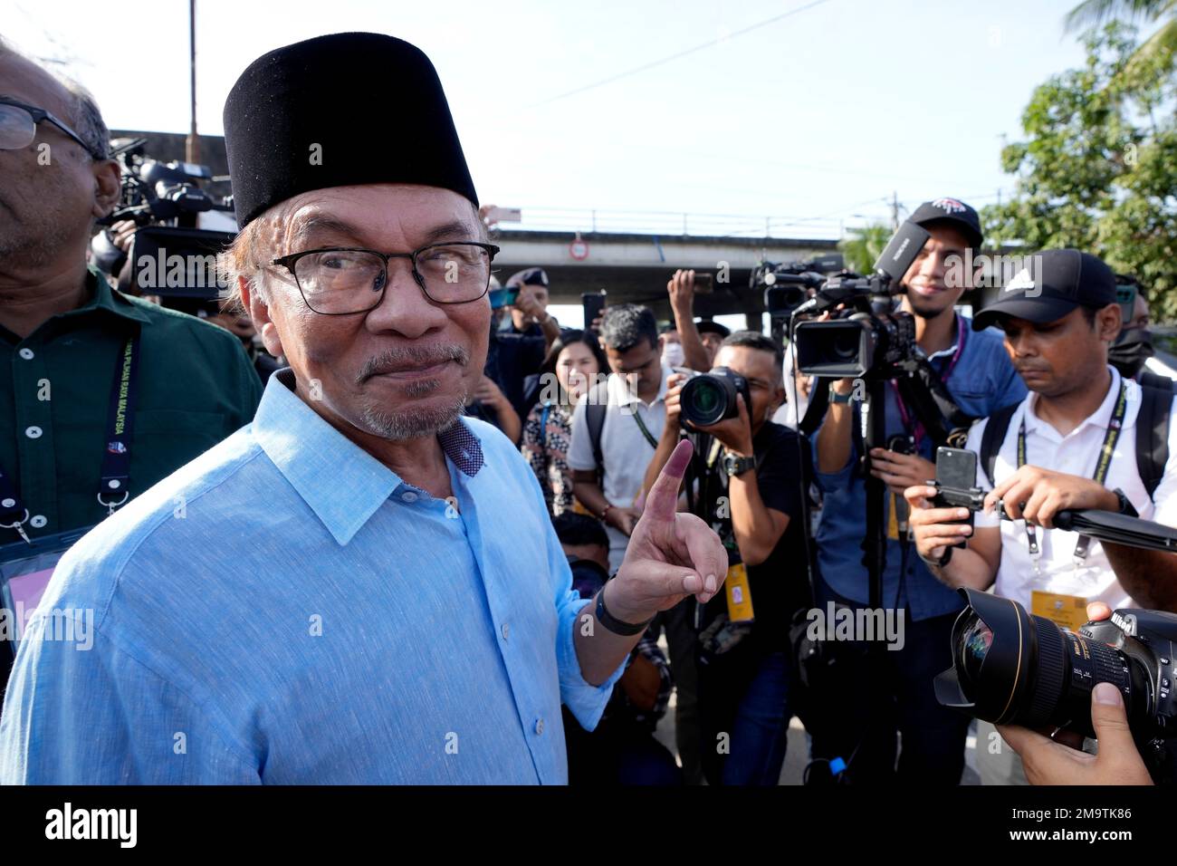 Malaysian opposition leader Anwar Ibrahim shows his inked finger to the media after voting at a ...