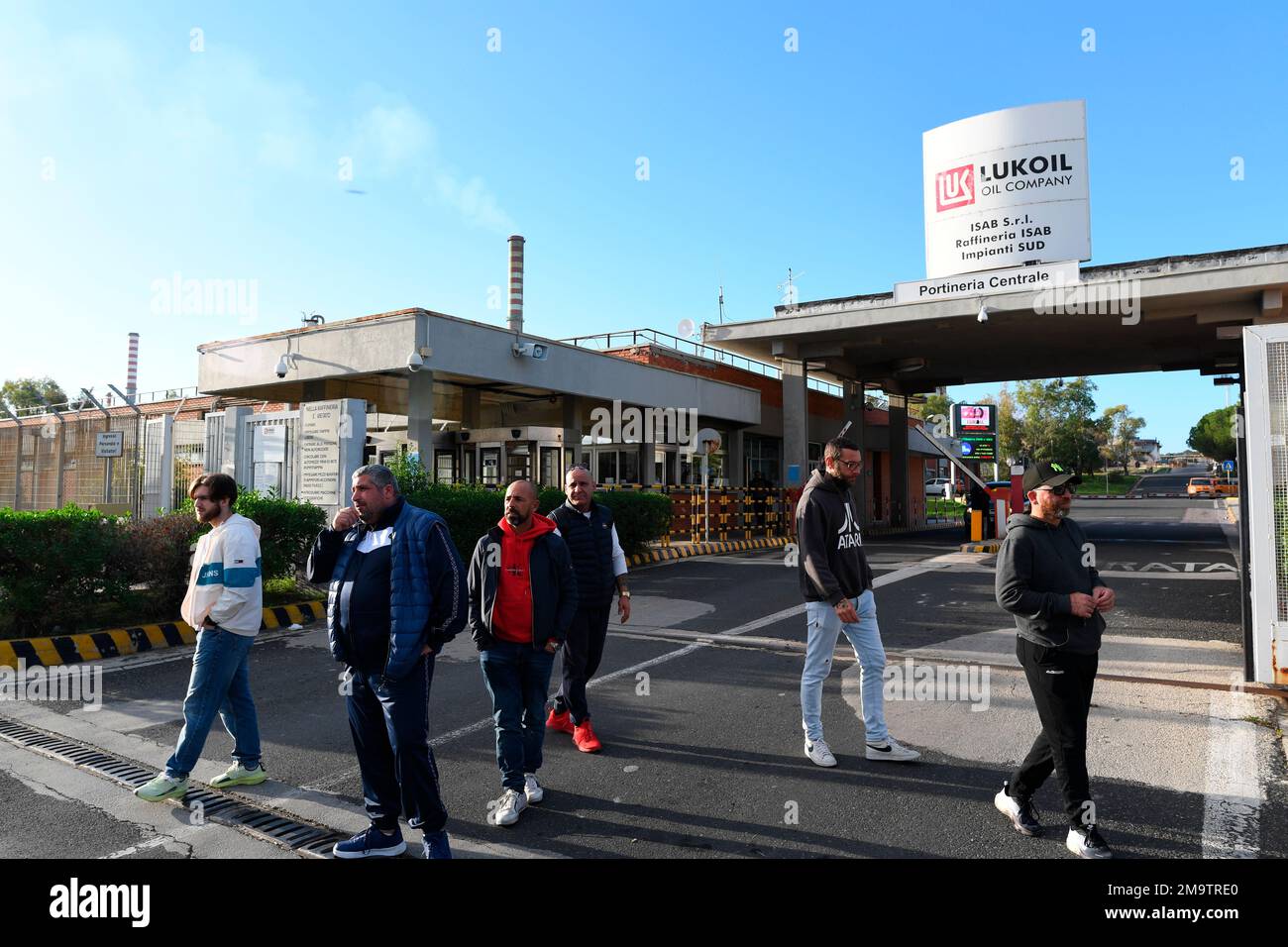 Workers stand in front of the main entrance of the Lukoil refinery ...