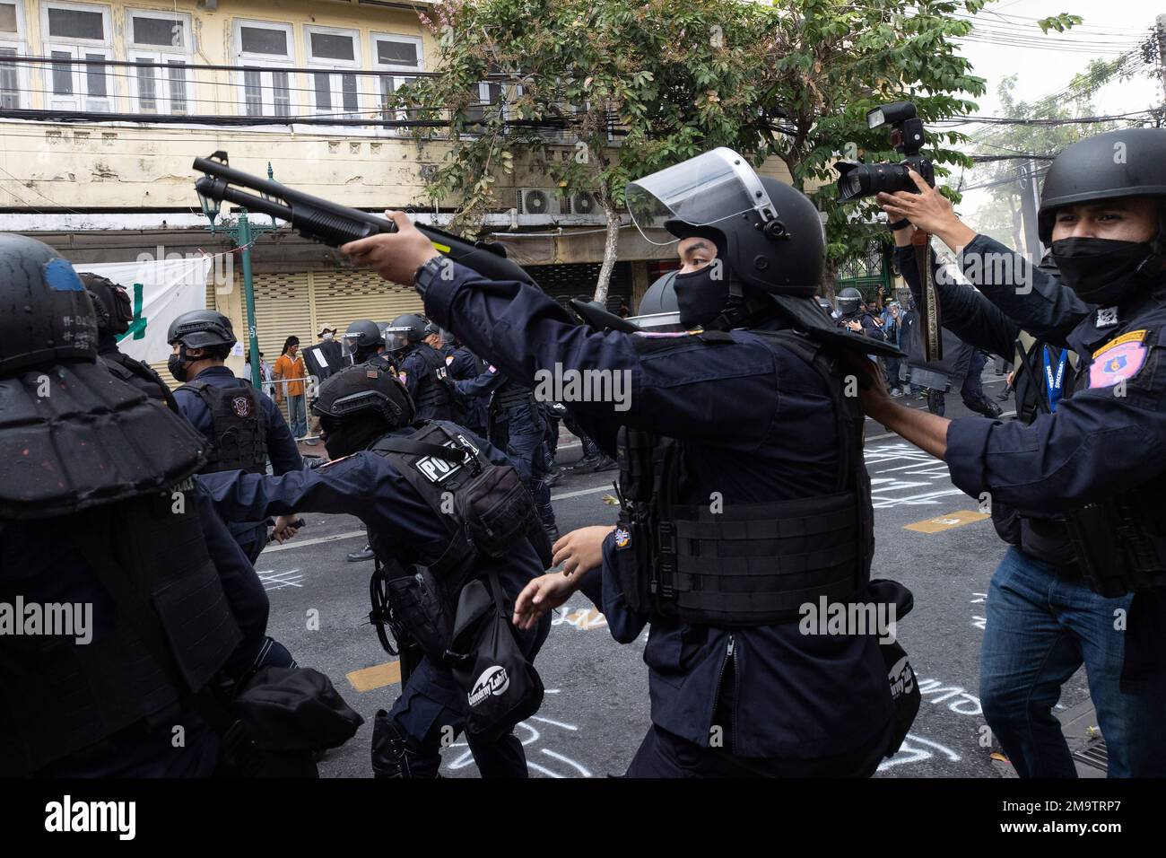 Police in riot gear aim a rubber bullet shotgun over protesters trying ...