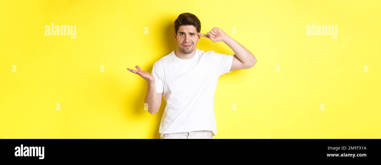 Confused and angry man pointing at head, scolding person for acting ...