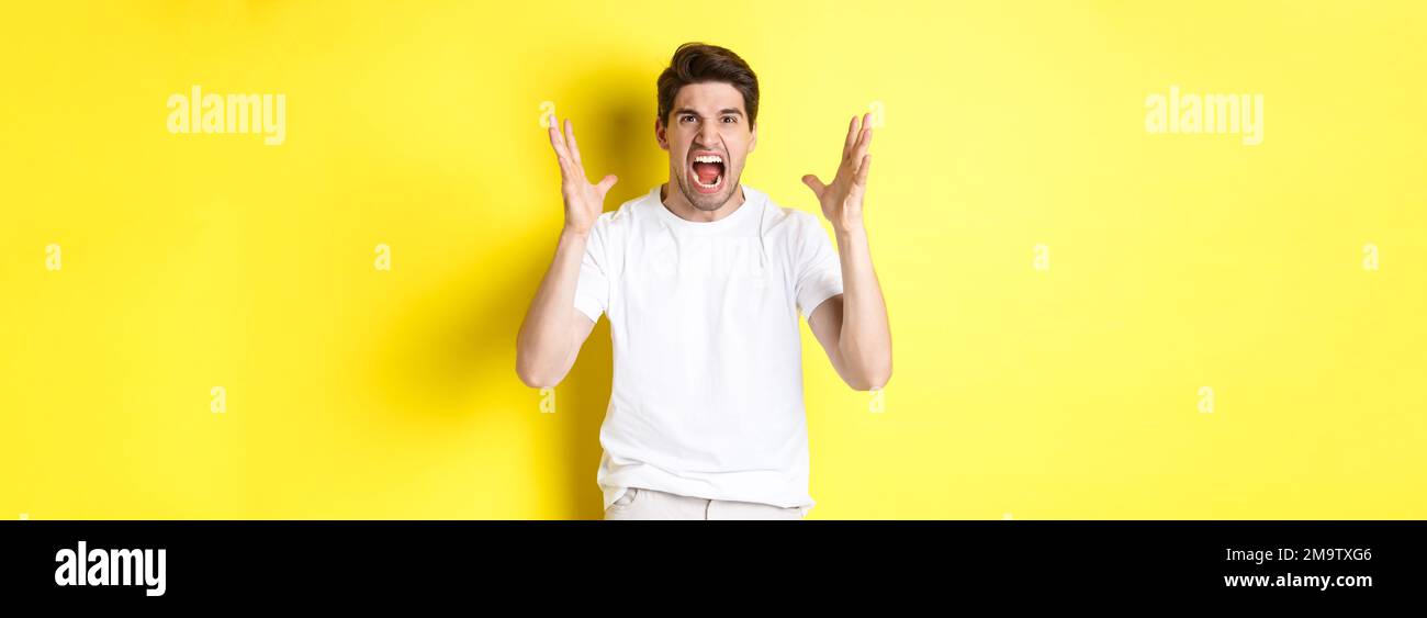 Angry man yelling and shaking hands, grimacing with hatred, standing ...