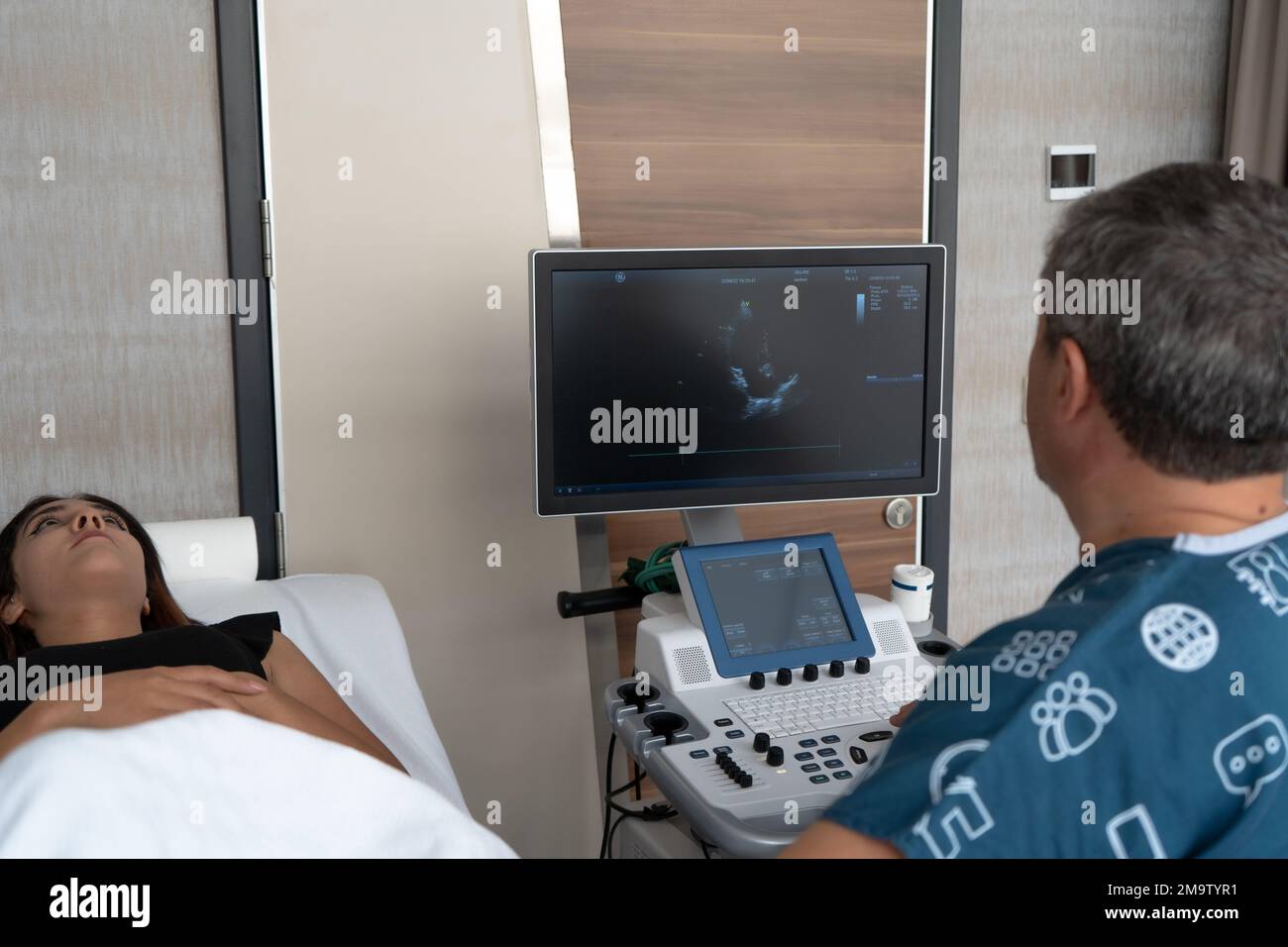 Doctor looking at ultrasound images, Doctor examining ultrasound of ...