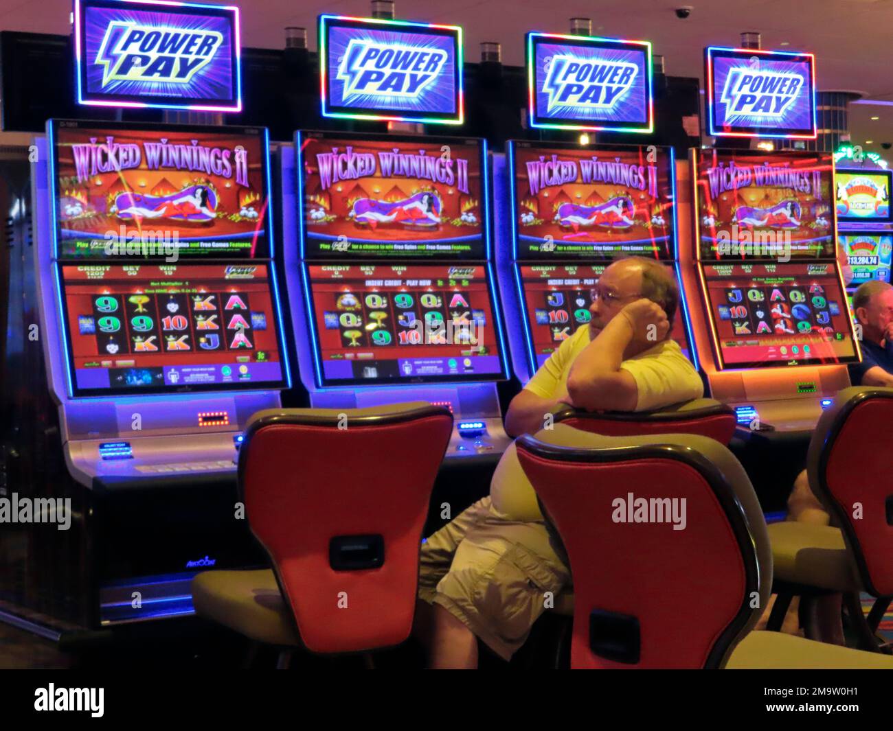 A man sits at a bank of slot machines at the Hard Rock casino in ...